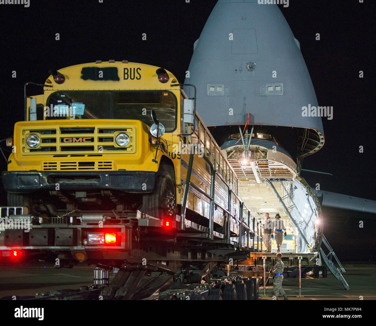 U.S. Airmen from the 60th Aerial Port Squadron load buses onto a C-5M ...