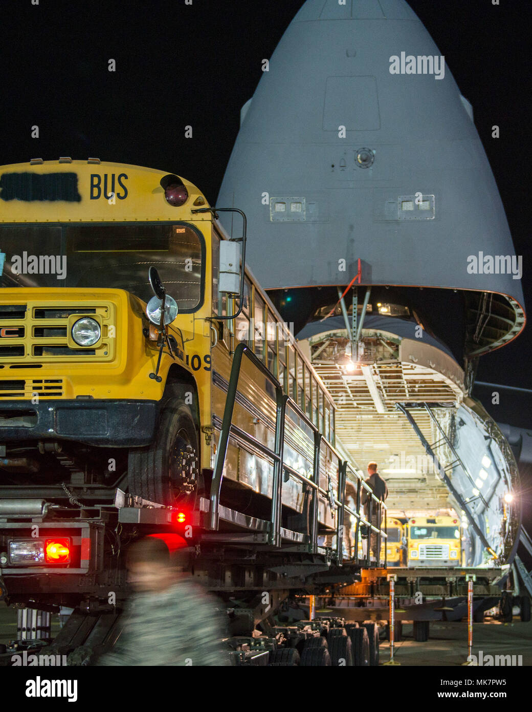 U.S. Airmen from the 60th Aerial Port Squadron load buses onto a C-5M ...