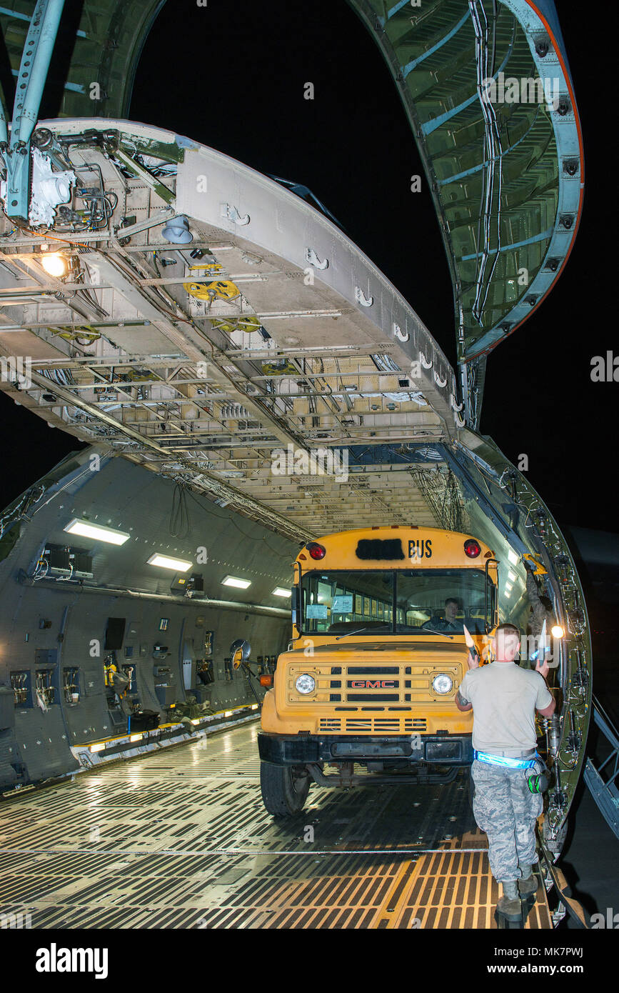 U.S. Airmen from the 60th Aerial Port Squadron load buses onto a C-5M ...