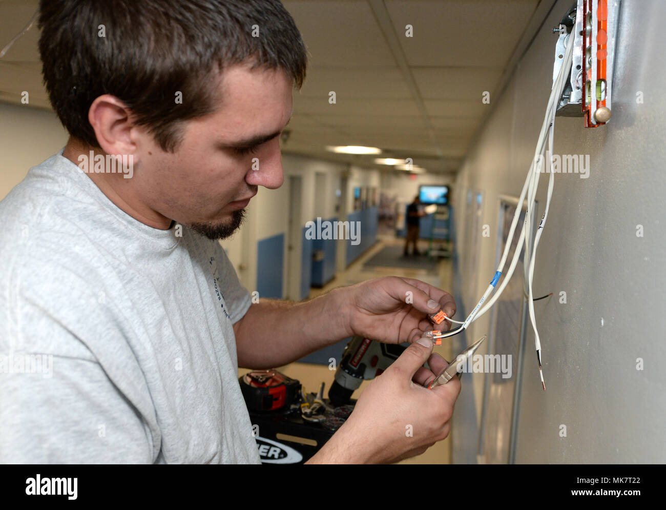 Anthony Brown, a contractor with Bazon-Cox, installs a sounder strobe ...