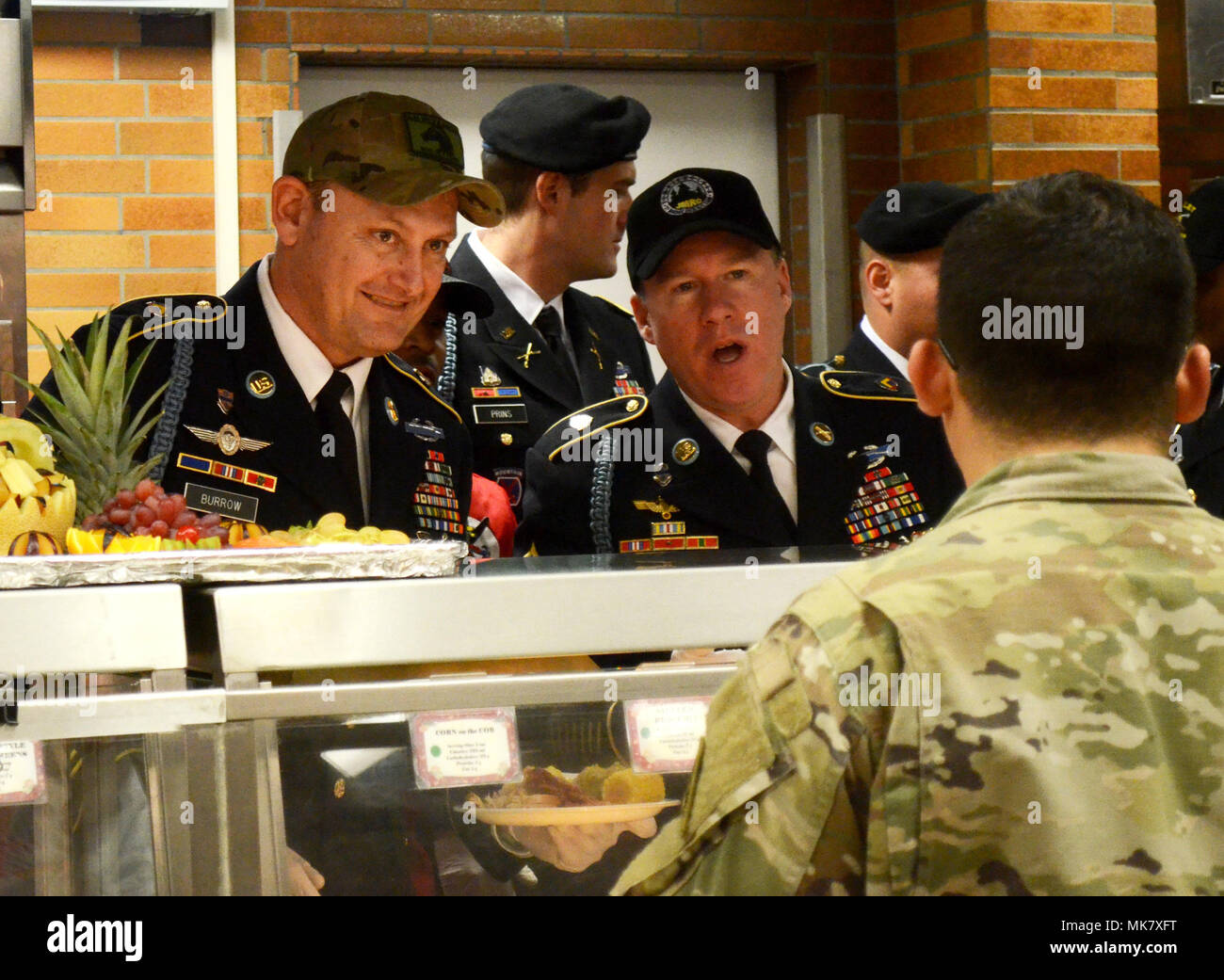 U.S. Army Command Sgt. Maj. Jay Morse (CTR) serves a Soldier his ...