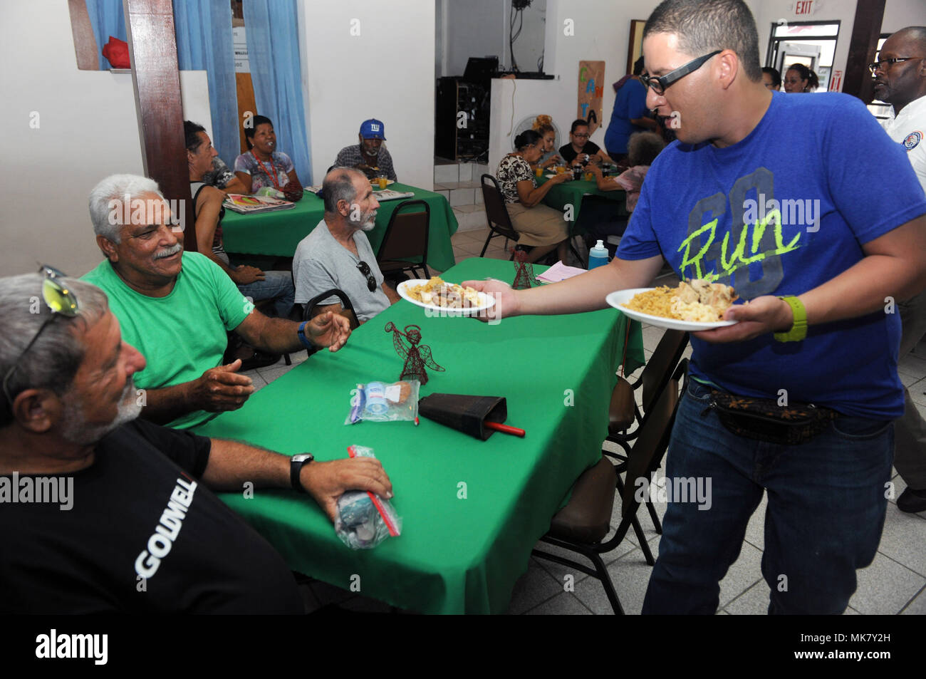 SAN JUAN, Puerto Rico – Volunteer Jonathan Rivera hands out plates ...