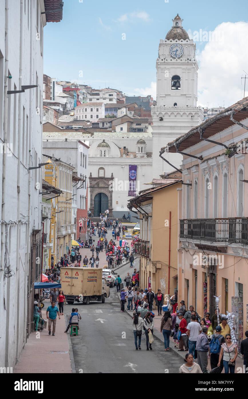 Pedestrians in a narrow street in the historic old city of Quito ...