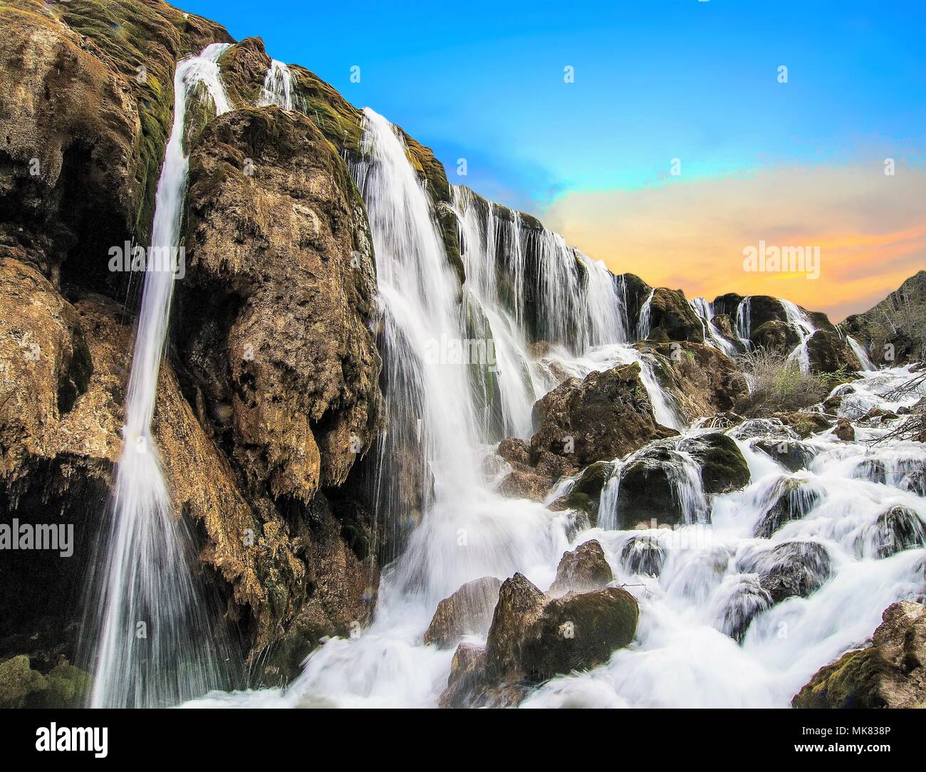 Amazing view of the Nuo Ri Lang Waterfall (Nuorilang) among woods and ...