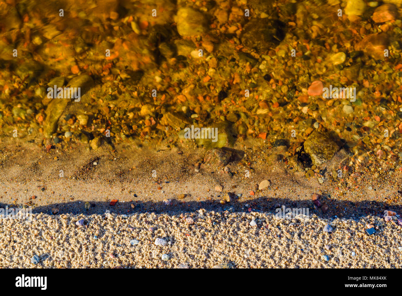 Abstract of riverbank with eroded sand and flowing water Stock Photo ...
