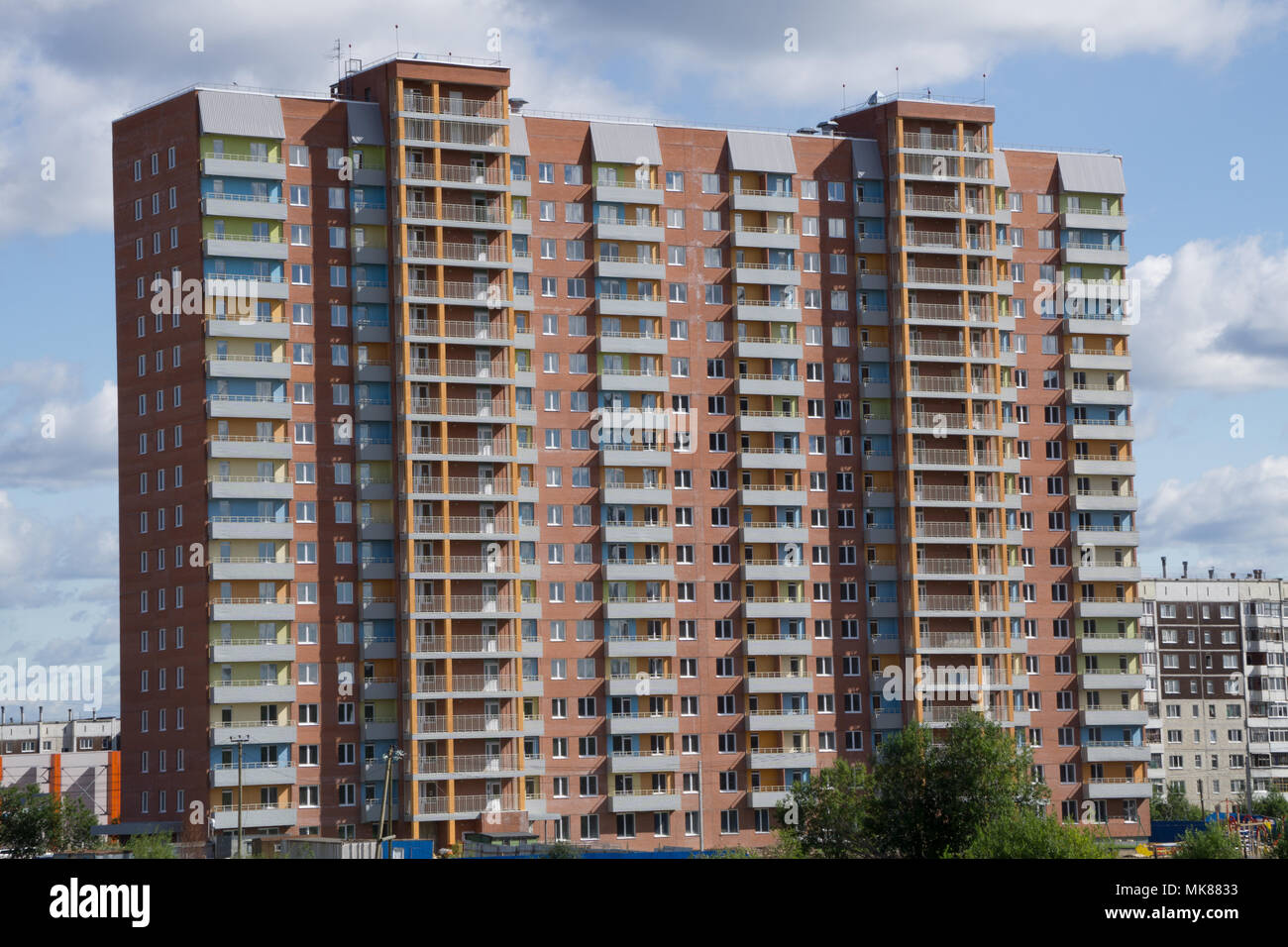 A multi-storey brick building under construction, against a blue sky ...