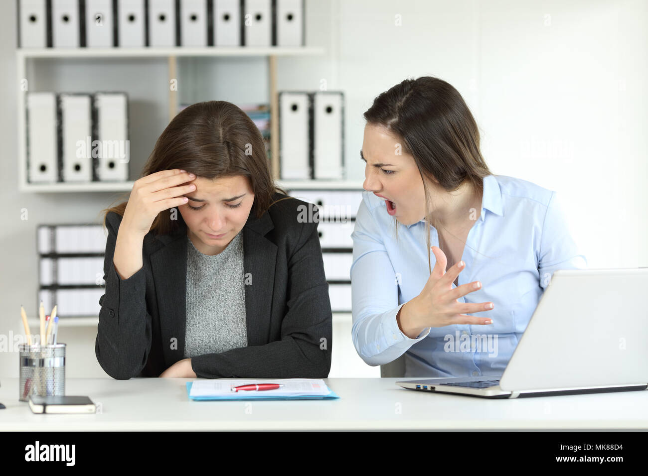 Boss scolding and shouting a sad employee at office Stock Photo - Alamy