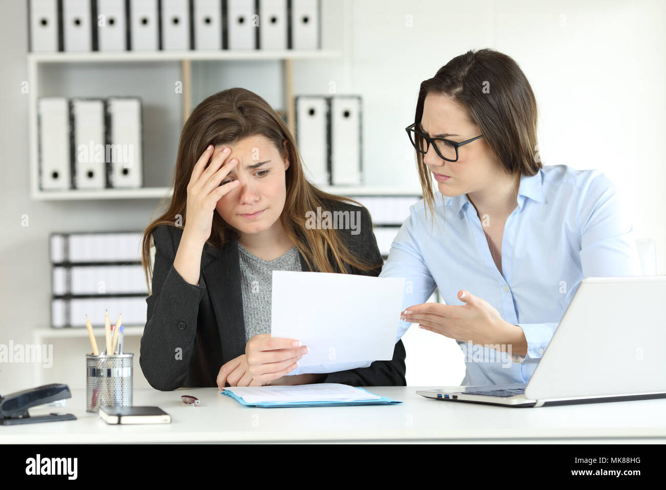 Boss scolding an intern showing a document at office Stock Photo - Alamy