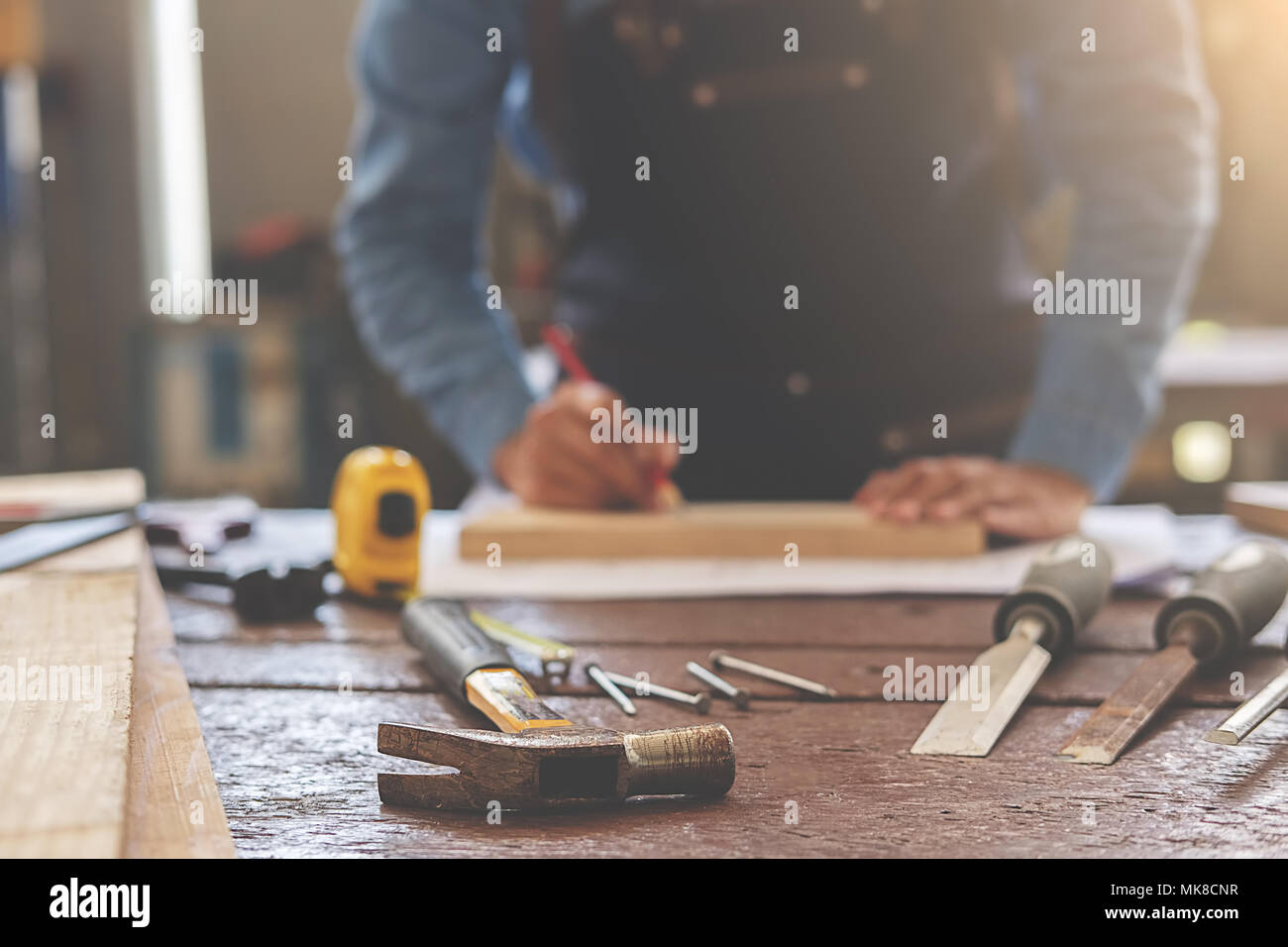 equipment on wooden desk with man working in workshop background Stock ...