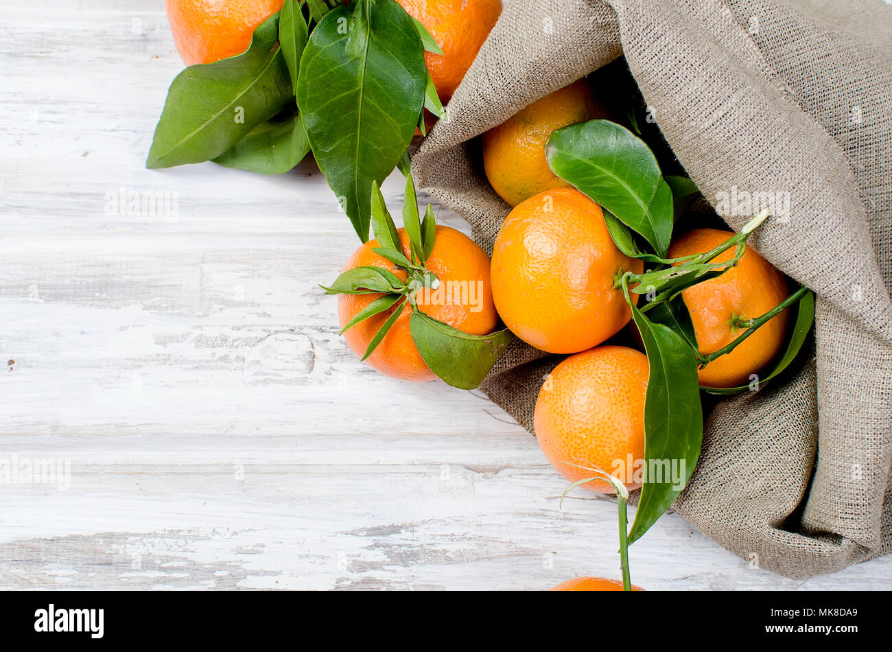 Fresh raw organic Tangerines clementine with green leaves in bag on ...