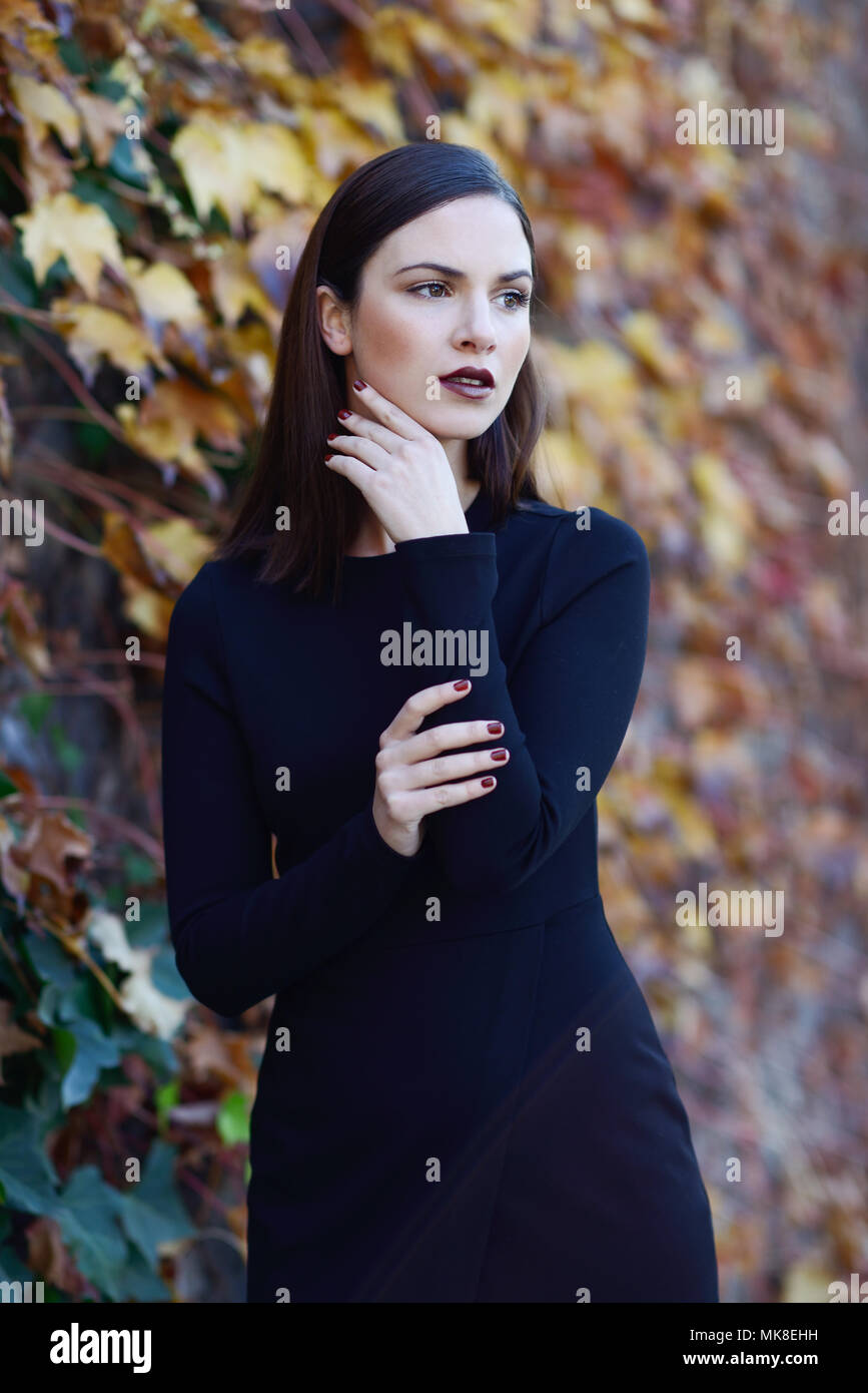 Beautiful young woman, model of fashion, wearing black dress in urban ...