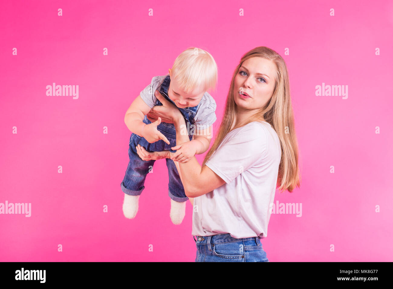 Funny family on pink background. Mother and her daughter girl. Mom and ...