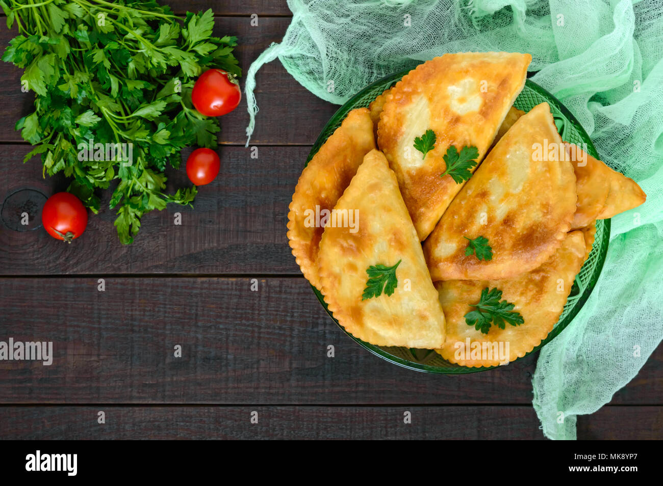 Juicy golden chebureks on a wooden table. Traditional Turkic-Mongolian ...