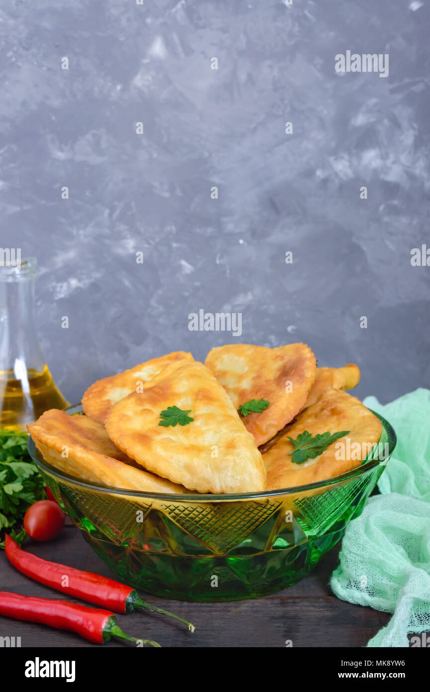Juicy golden chebureks on a wooden table. Traditional Turkic-Mongolian ...