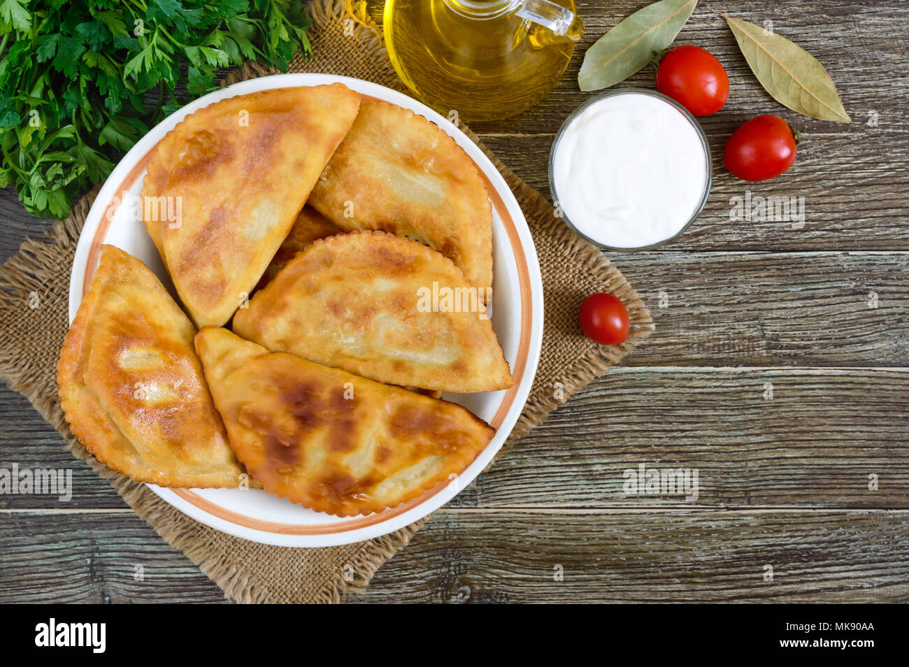 Juicy golden chebureks on a wooden table. Traditional Turkic-Mongolian ...