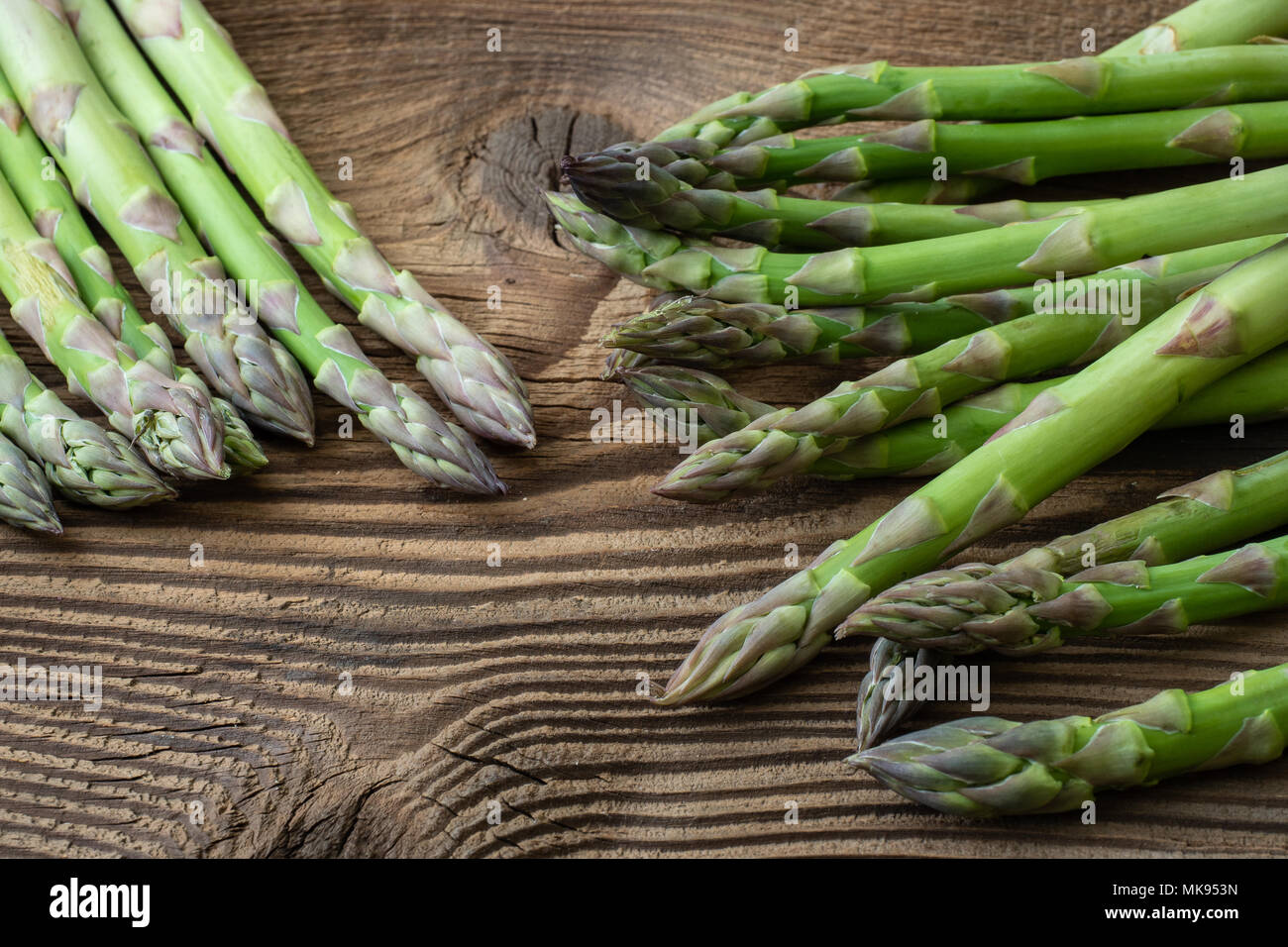 Raw garden asparagus stems. Fresh green spring vegetables on wooden ...