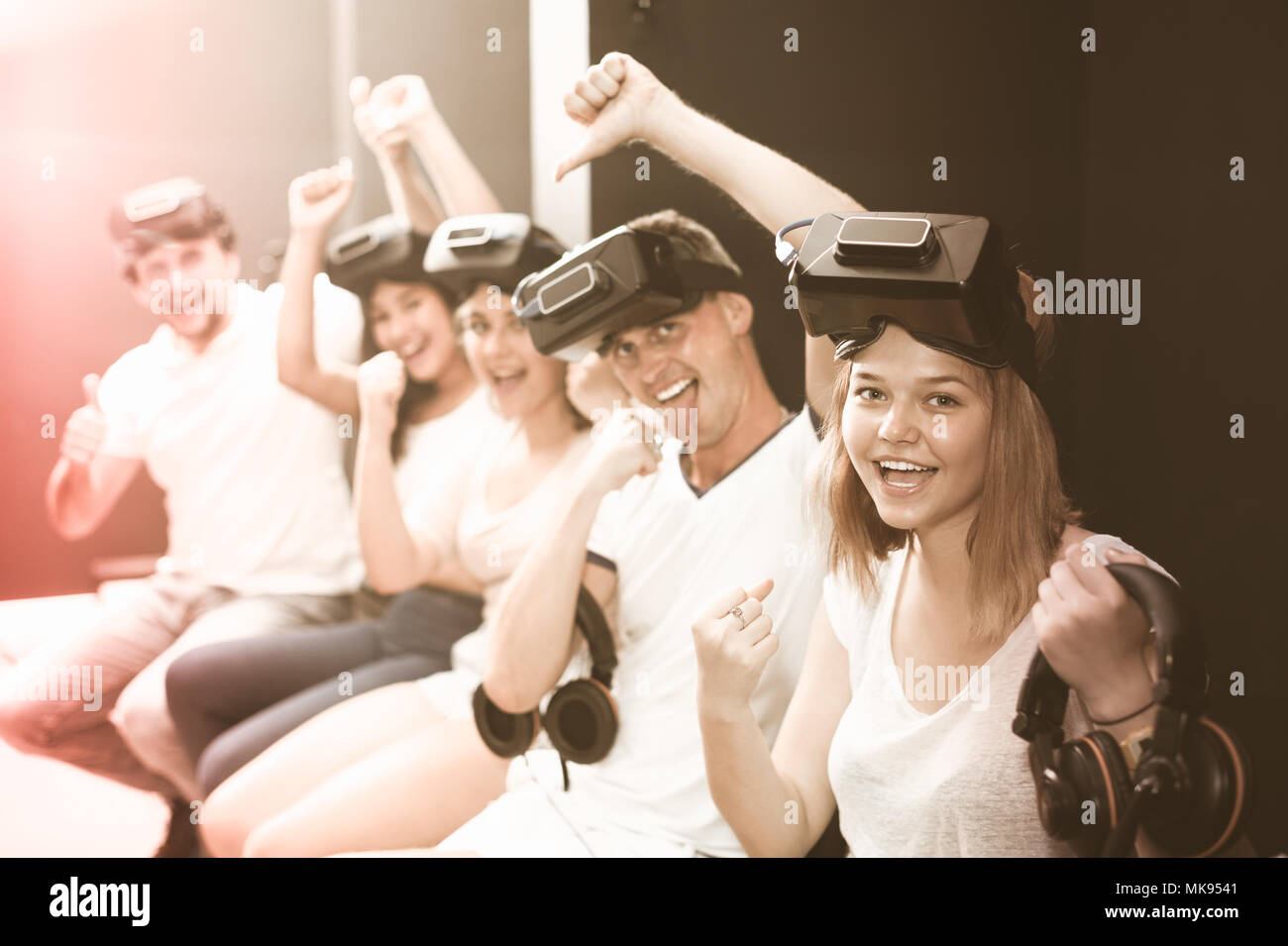 Group of cheerful friends are wearing virtual reality goggles and ...
