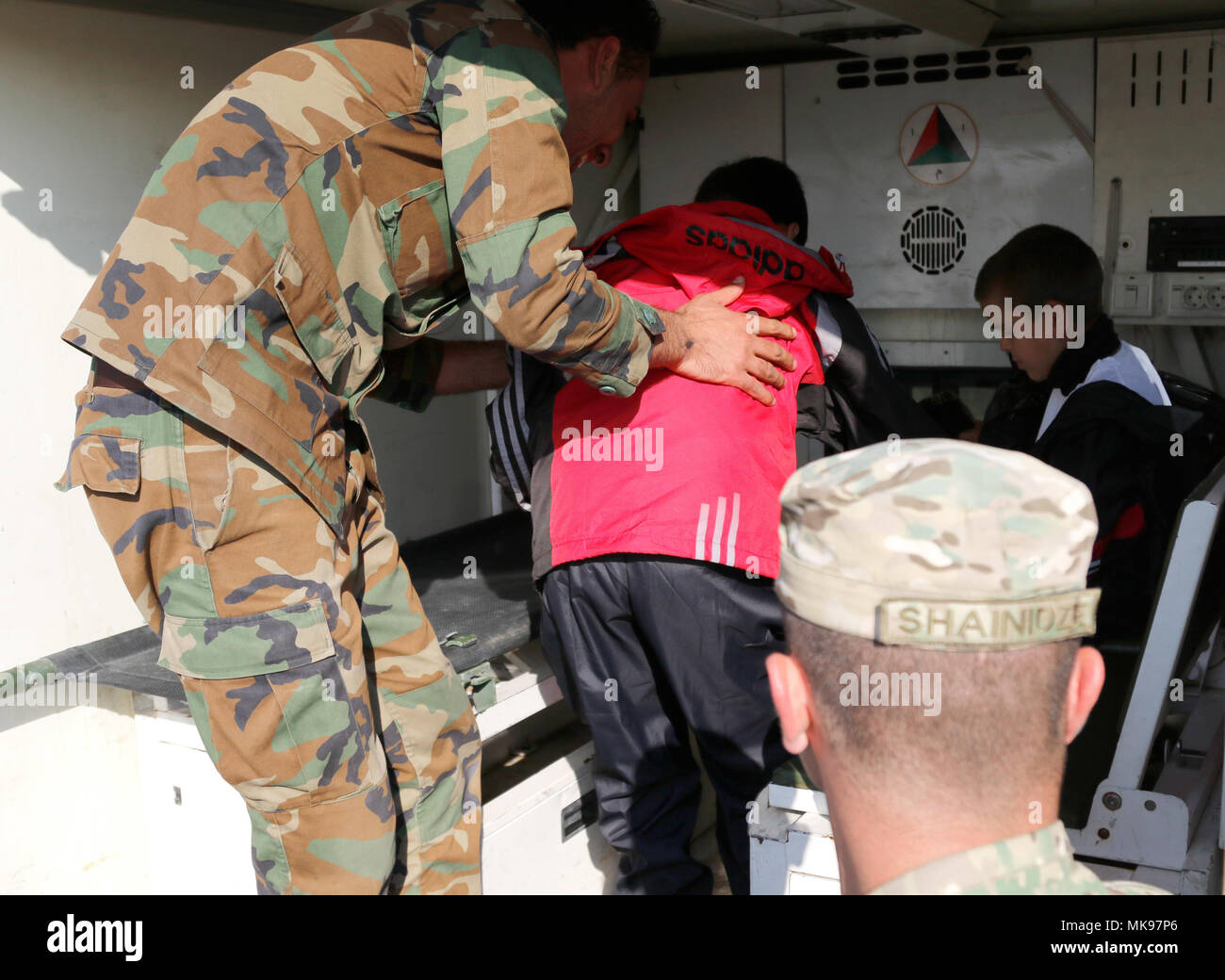 Soldiers from the Afghan National Army and Georgian Army help the boys ...