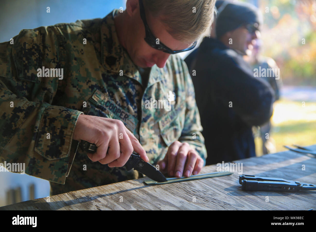 Staff Sgt. Harold Cooper prepares a small explosive charge used for low ...