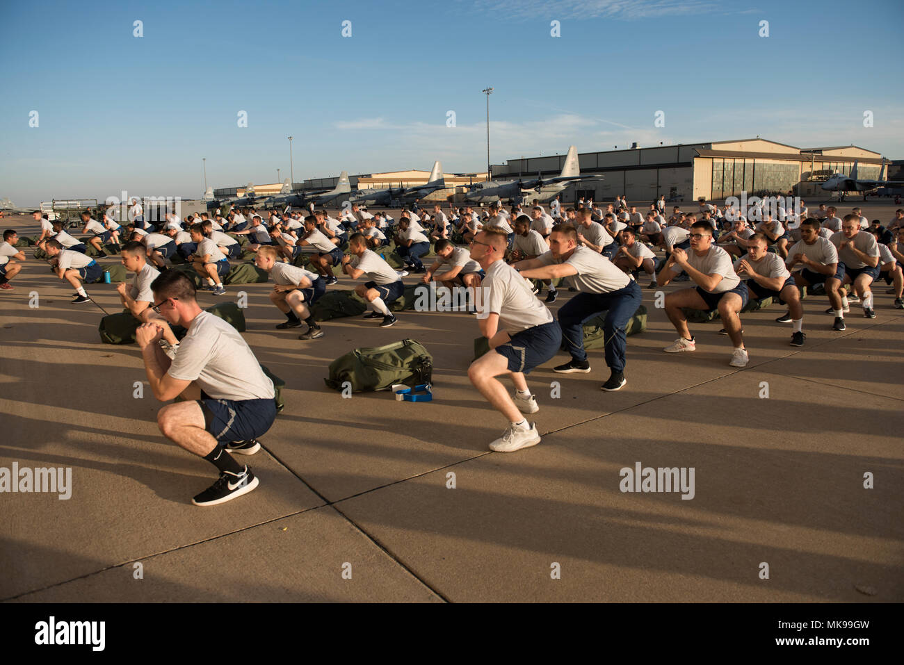 Airmen in the 363rd Training Squadron, perform squats during a physical ...