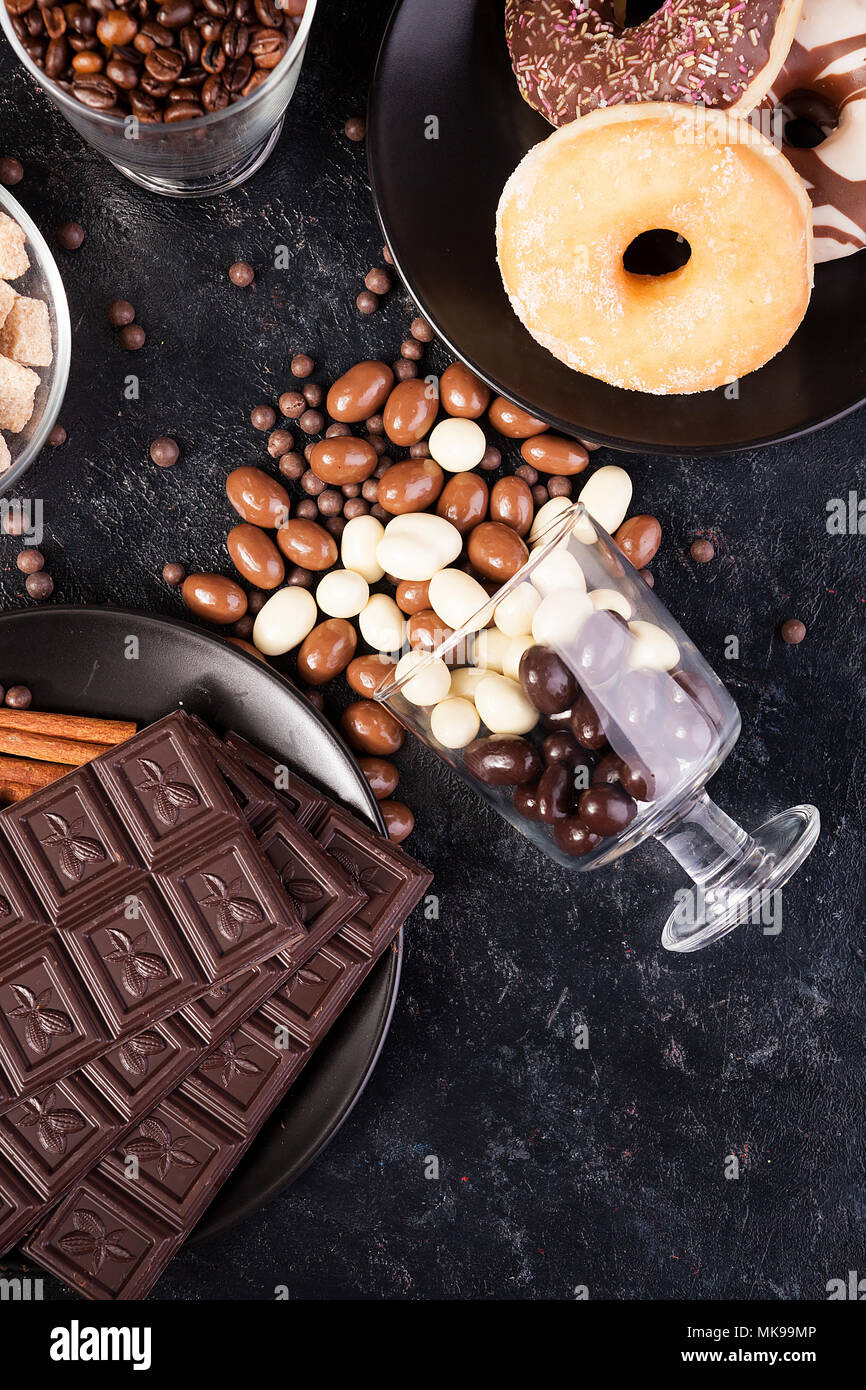 Top view of peanuts in chocolate, spilled on the dark board, next to ...
