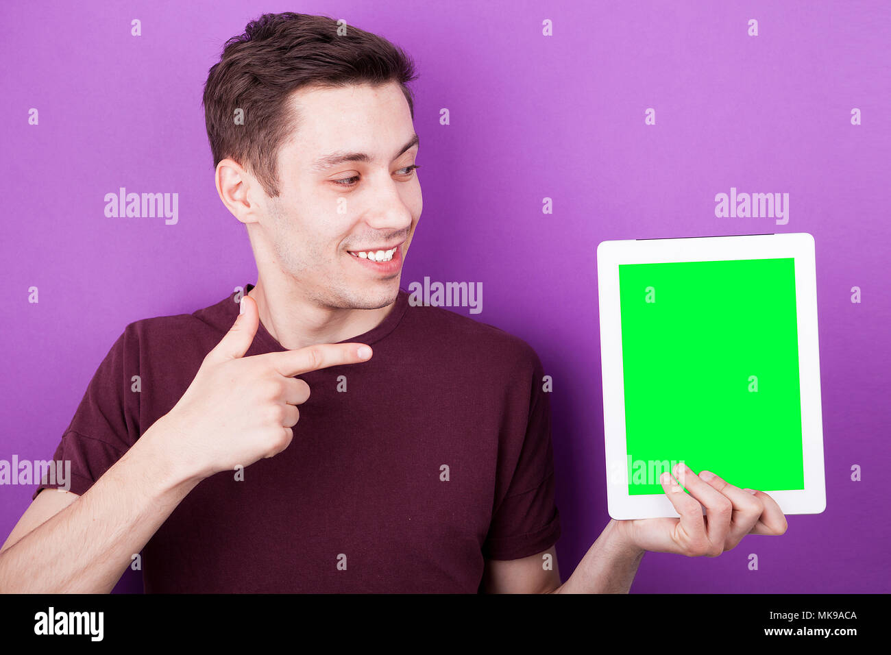 Smiling man pointing with his finger to a digital tablet screen Stock ...