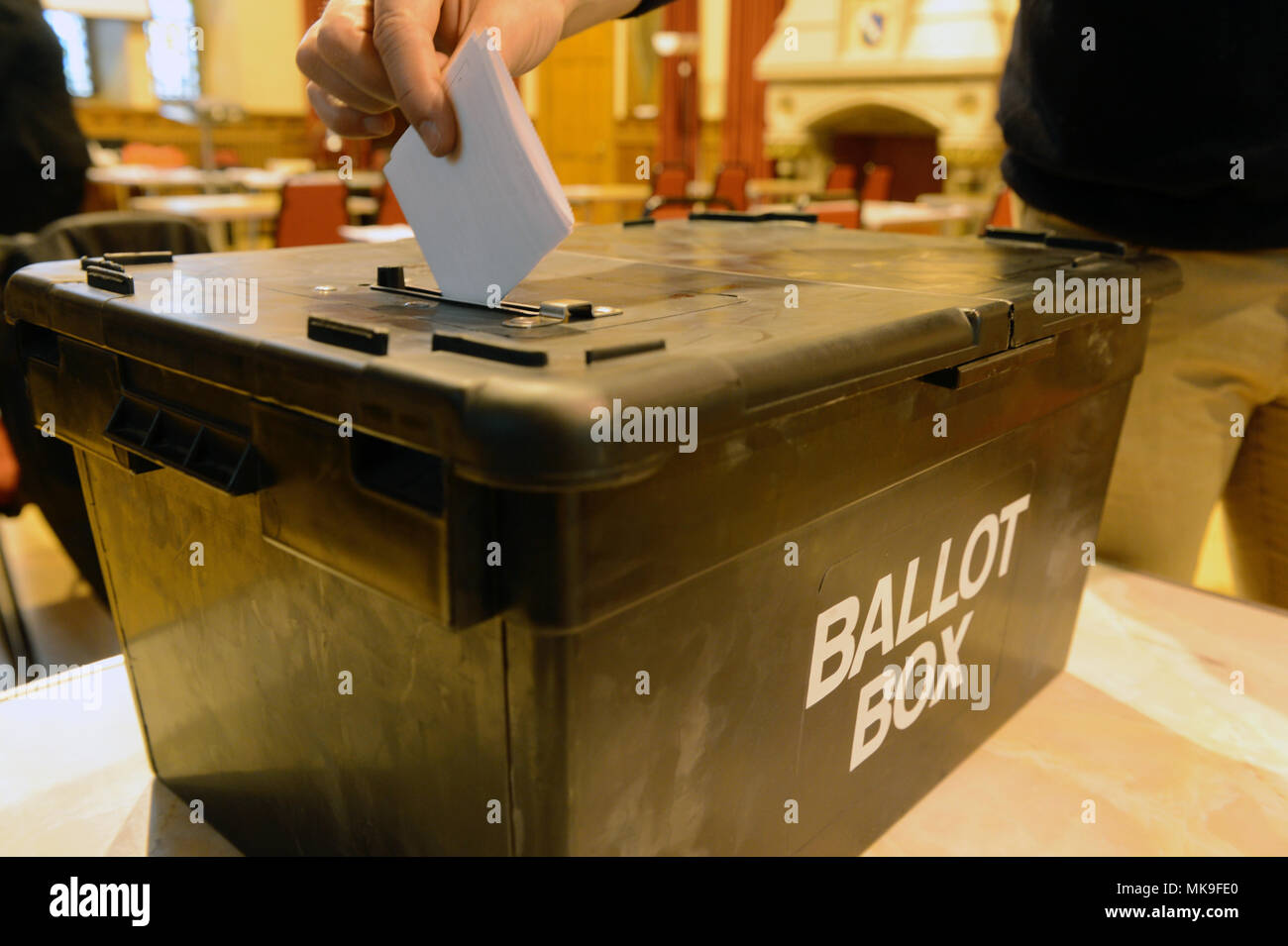 Person posting a vote into a ballot box during an election Stock Photo ...