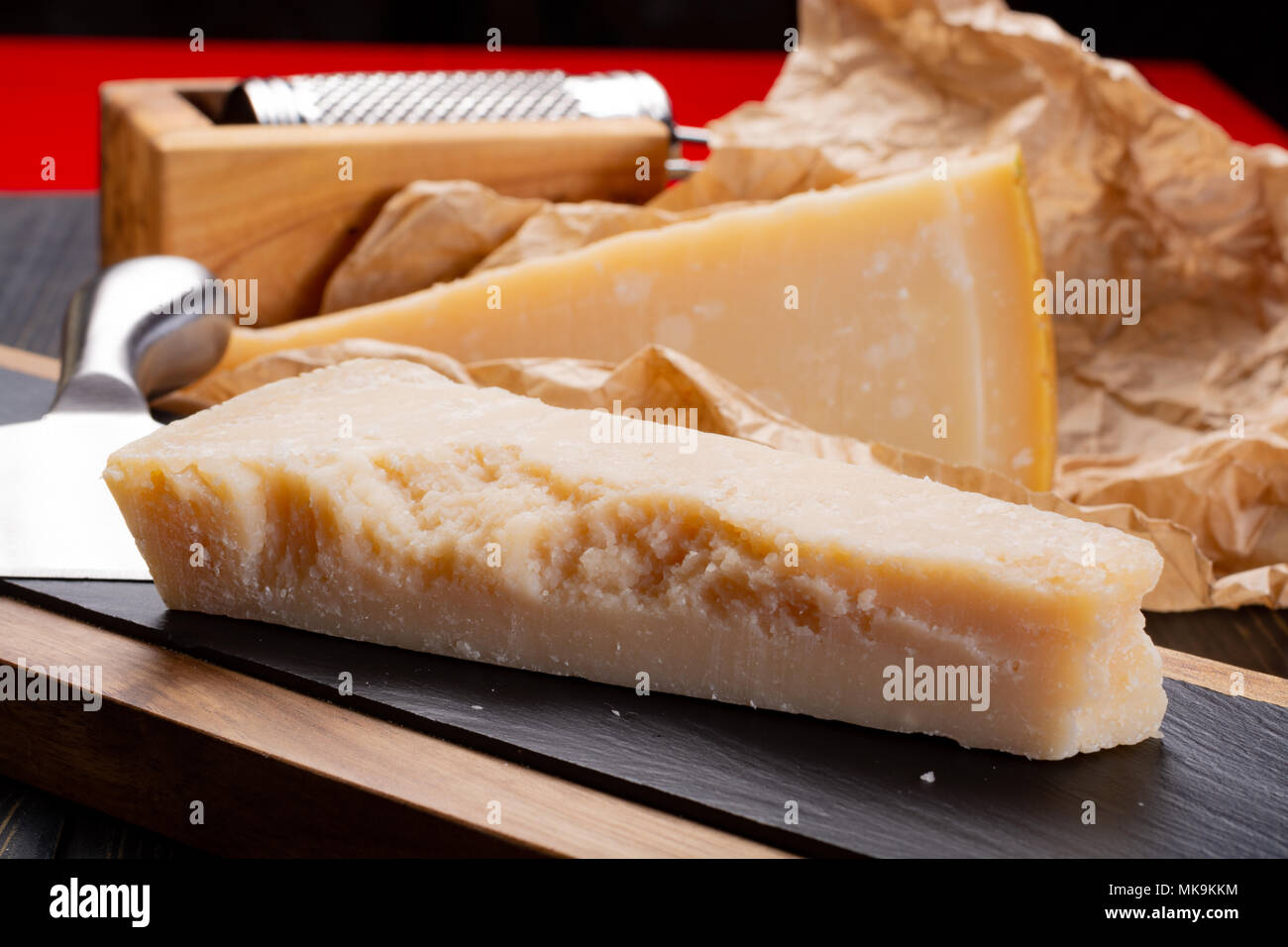 Aged Italian parmesan hard cheese Parmigiano-Reggiano with cheese knife ...