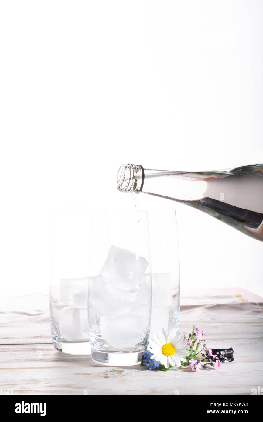 Pouring of stil mineral drink water in glasses with ice cubes copy space Stock Photo - Alamy
