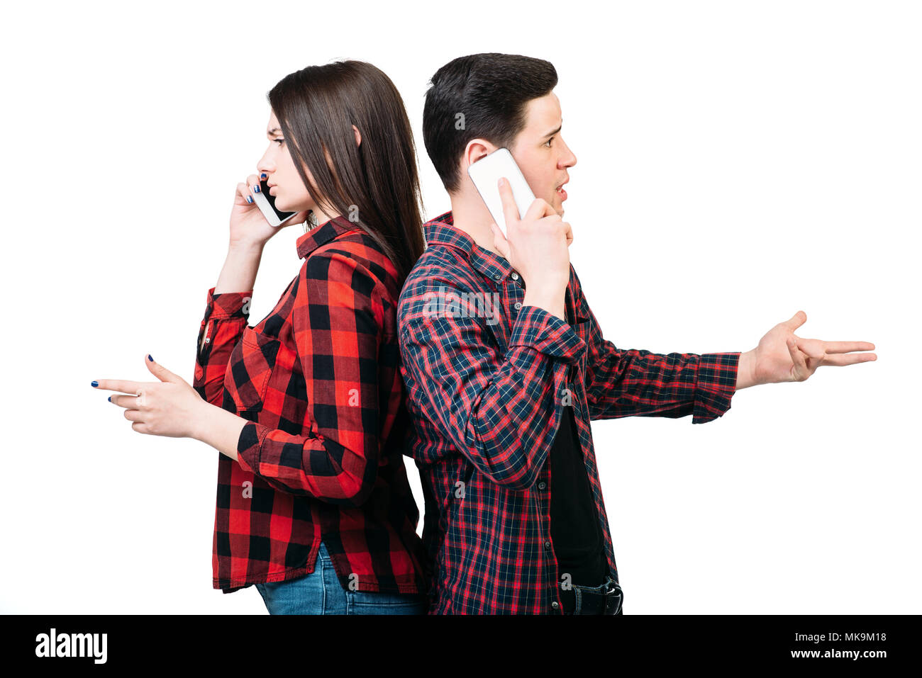 Smartphone addicted people. Couple standing back to back, talking by ...