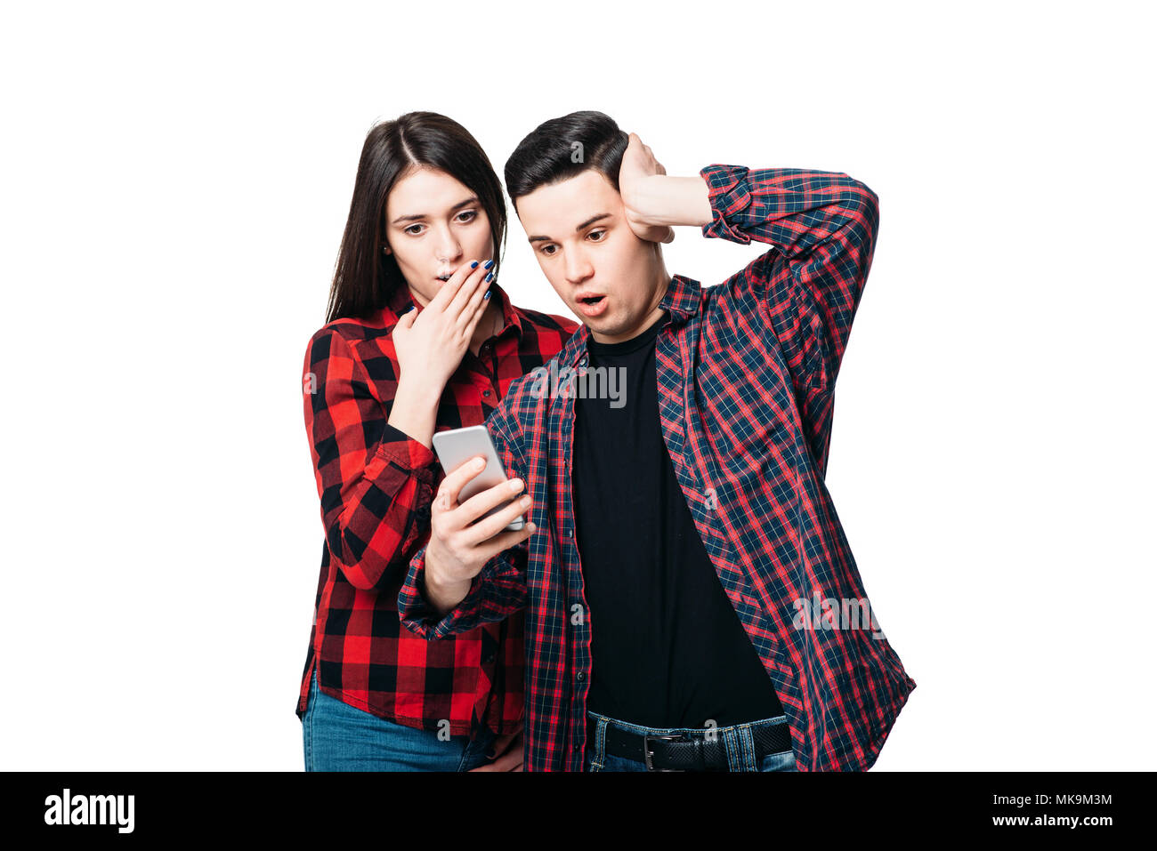 Phone addiction, surprised couple looks on smartphone screen, white ...