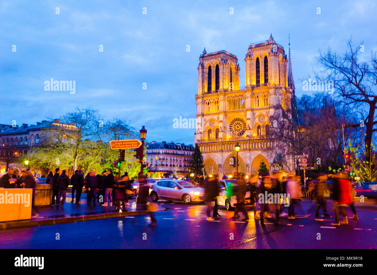 Pedestrians and vehicle crossing along a busy intersection in Paris ...
