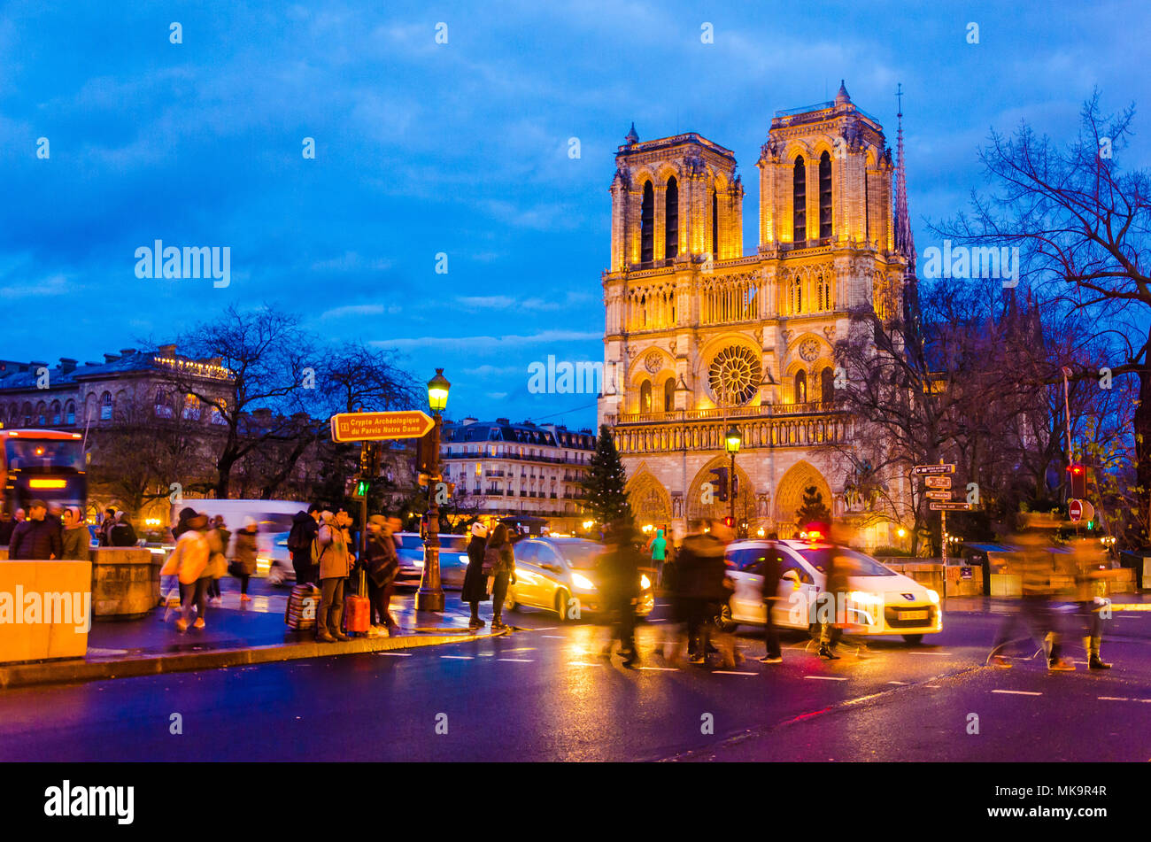 Pedestrians and vehicle crossing along a busy intersection in Paris ...