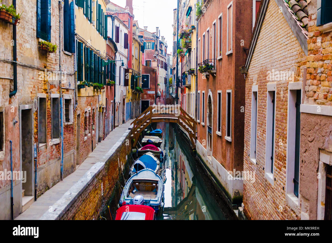 Narrow water alley with old traditional residential housing and ...