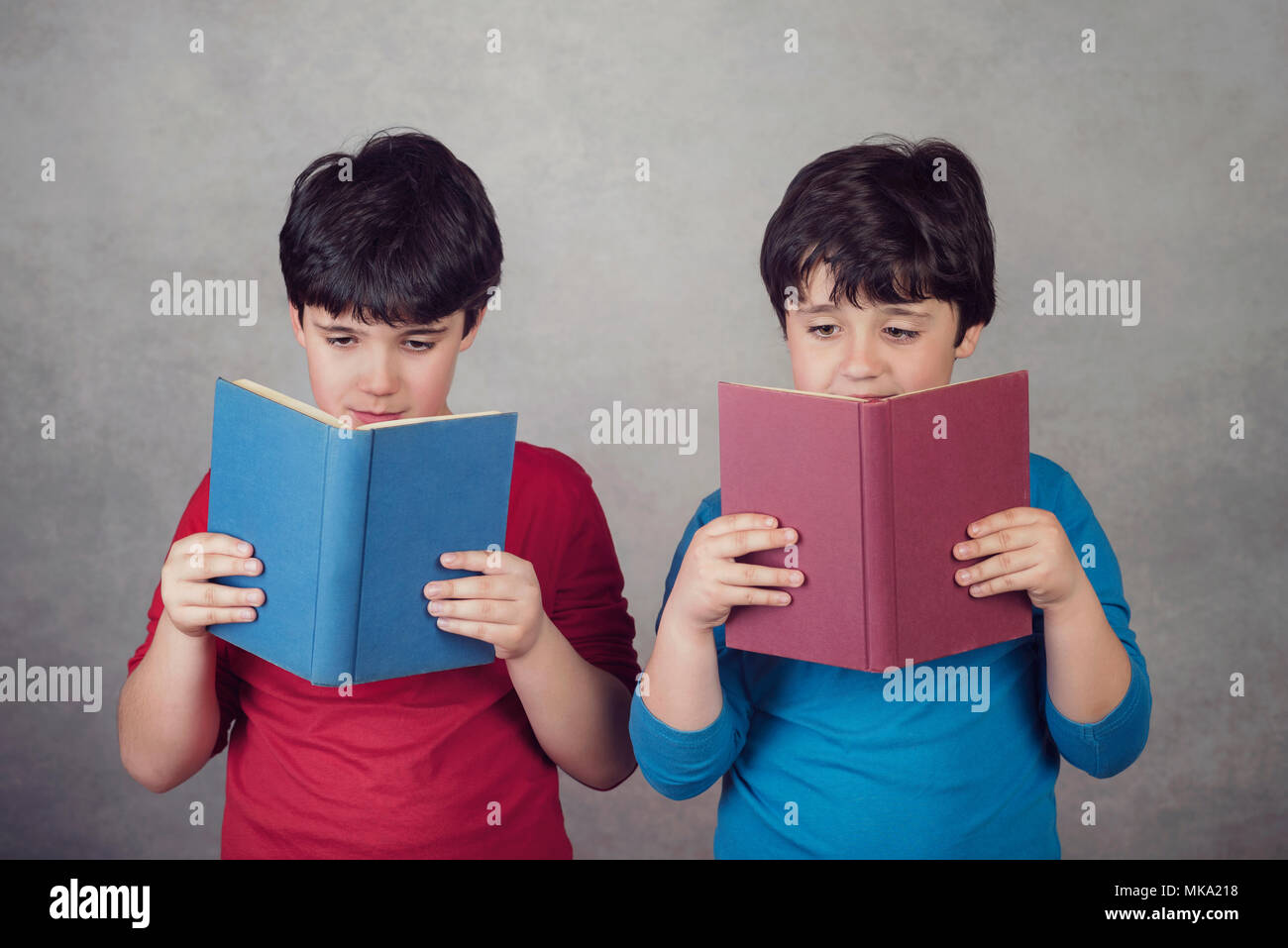 children reading a book on gray background Stock Photo - Alamy