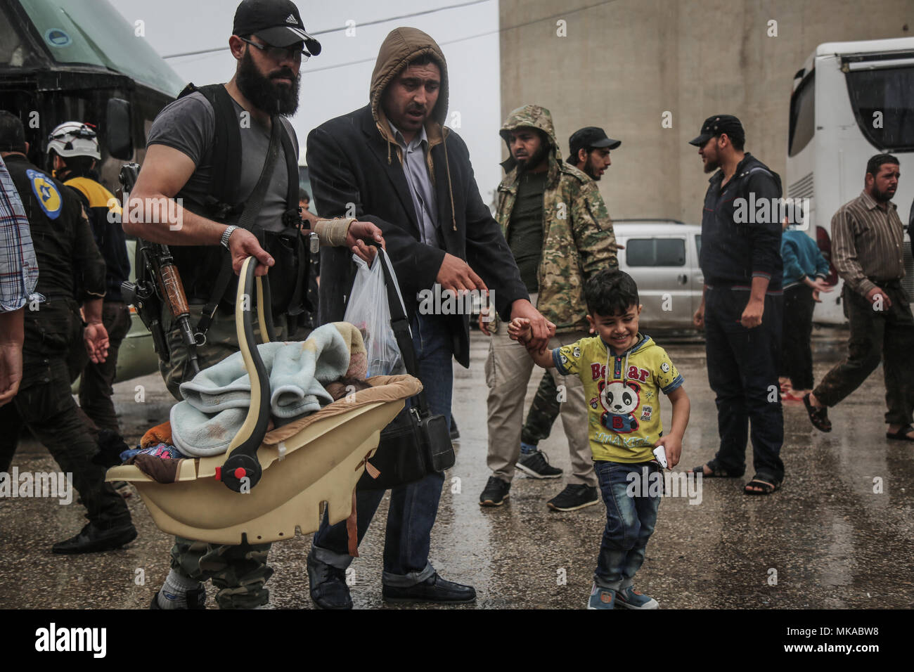 Hama, Syria. 07th May, 2018. A Syrian opposition fighter helps a family ...