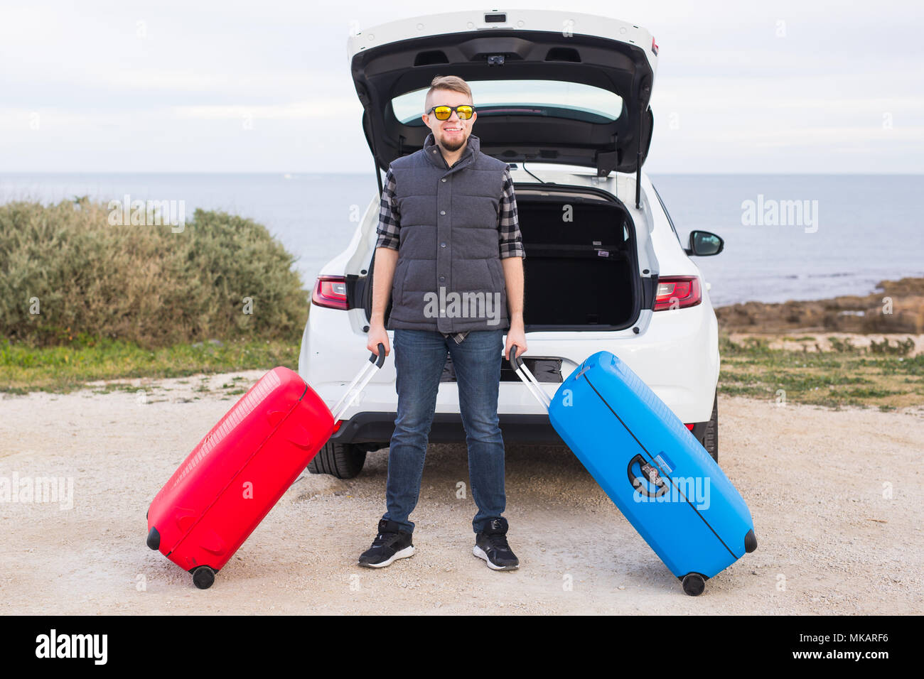 Man standing in back of car smiling and getting ready to go. Young ...