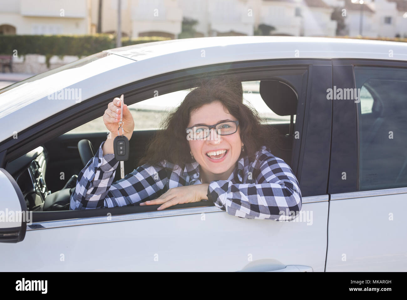 Young woman test drive new car and showing key. Car purchase or rental ...