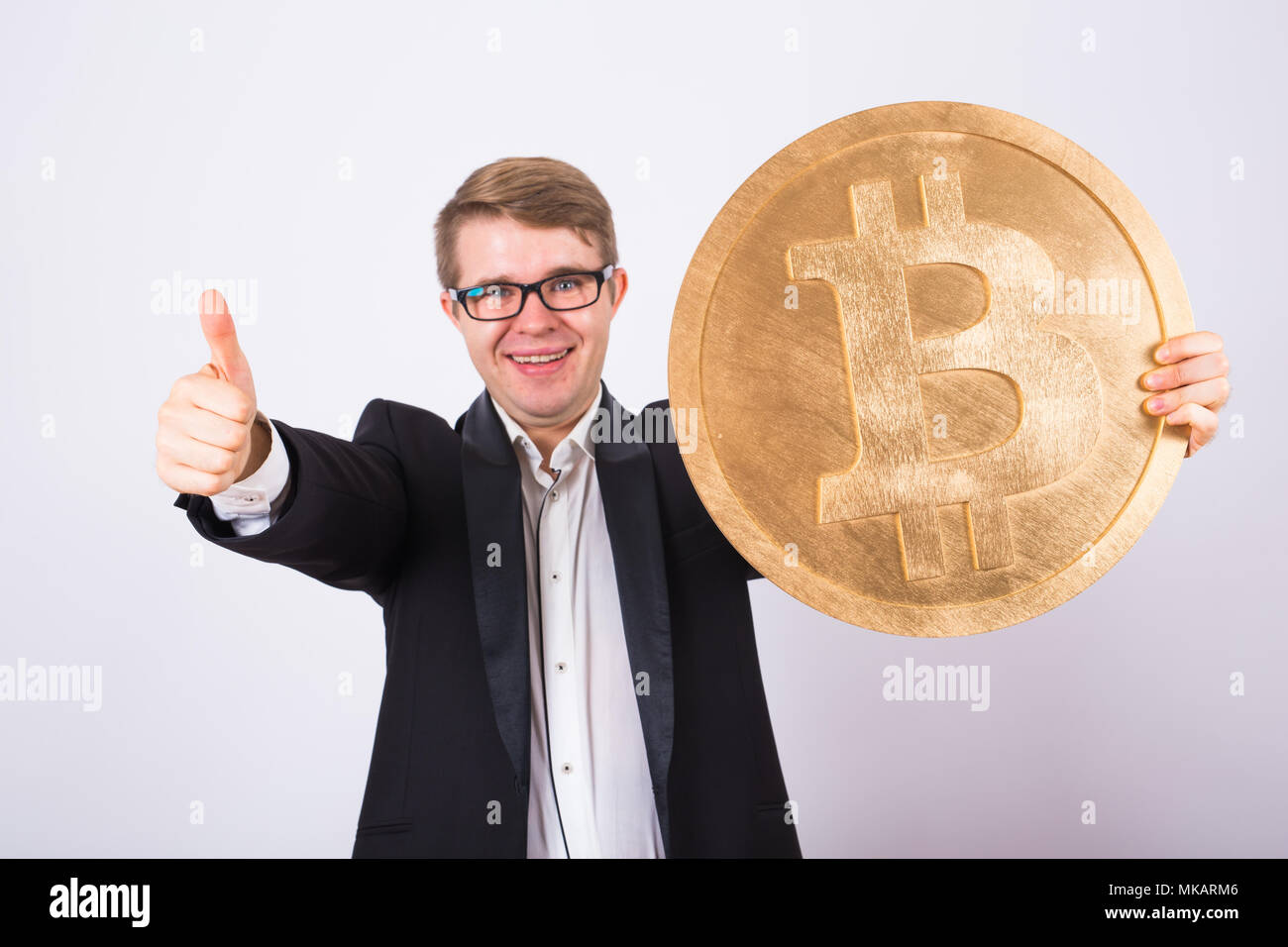 happy man holding big bitcoin and showing thumbs up Stock Photo - Alamy