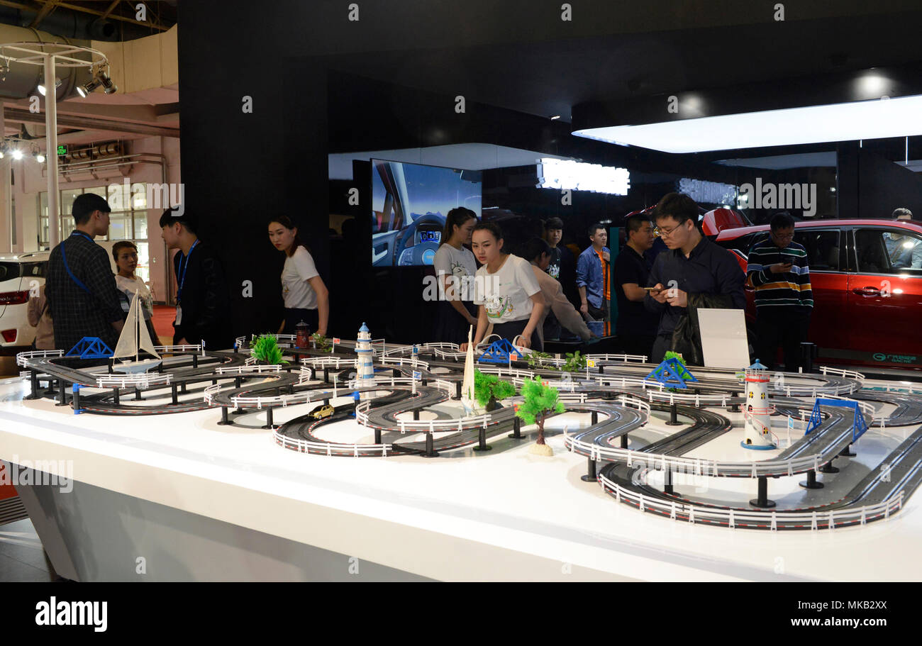 Visitors investigate a model car racetrack on the GAC stand at the Auto ...