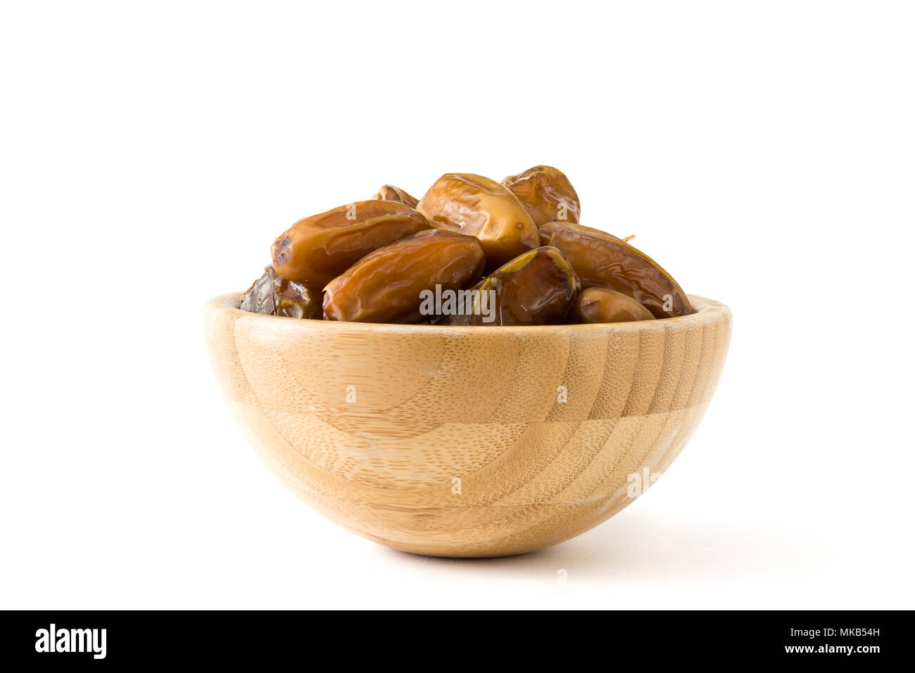 Dates food in wooden bowl isolated on white background Stock Photo - Alamy