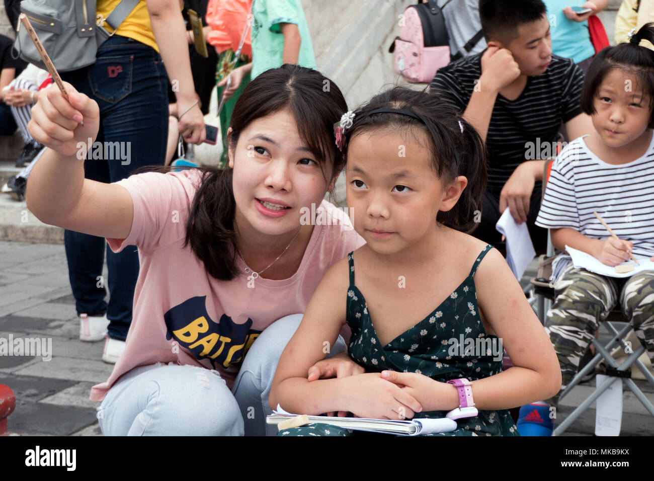 Chinese school child learning drawing and painting with teacher in ...