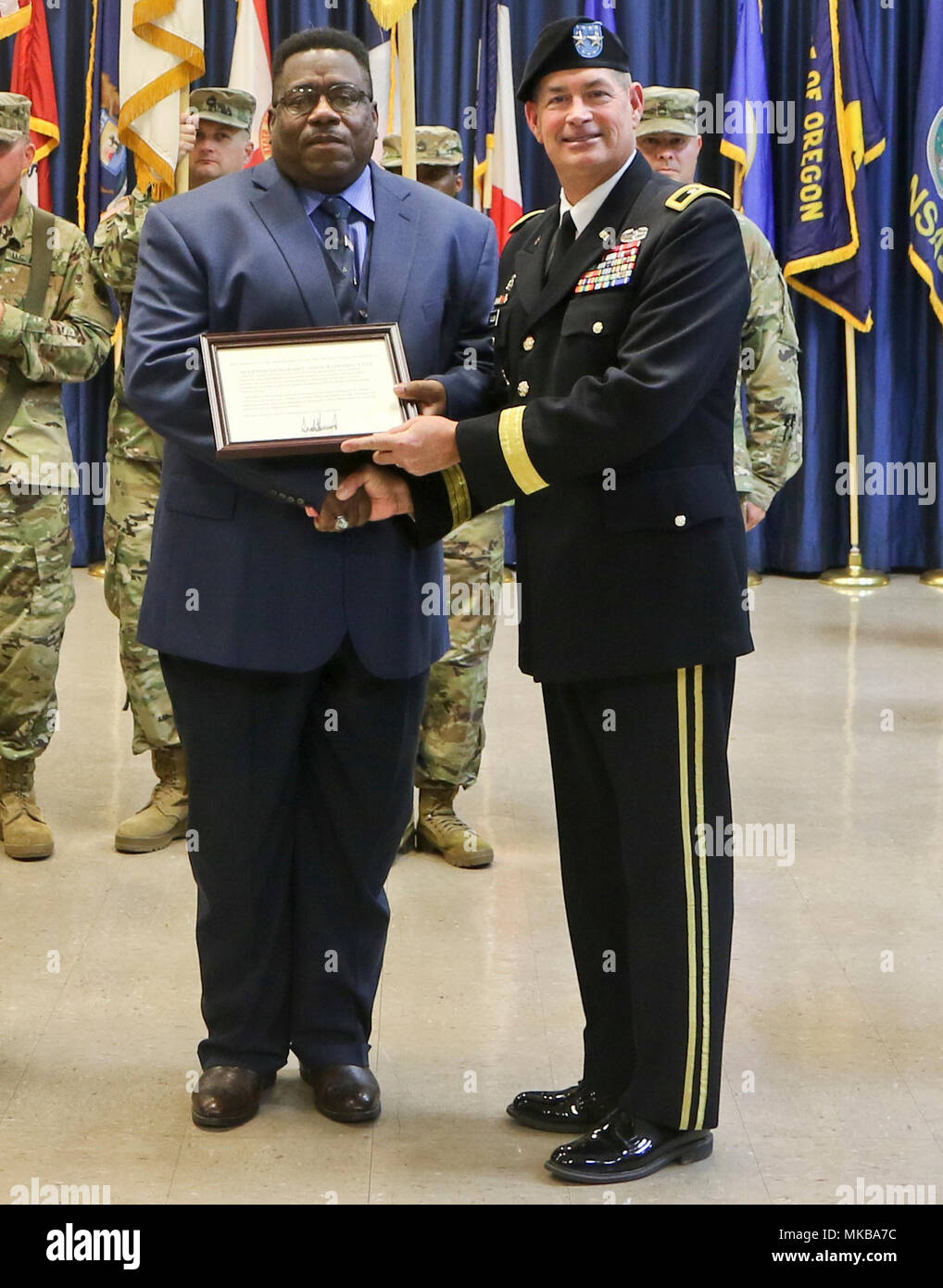 Retiree Msg. John Tate is congratulated with a certificate of ...