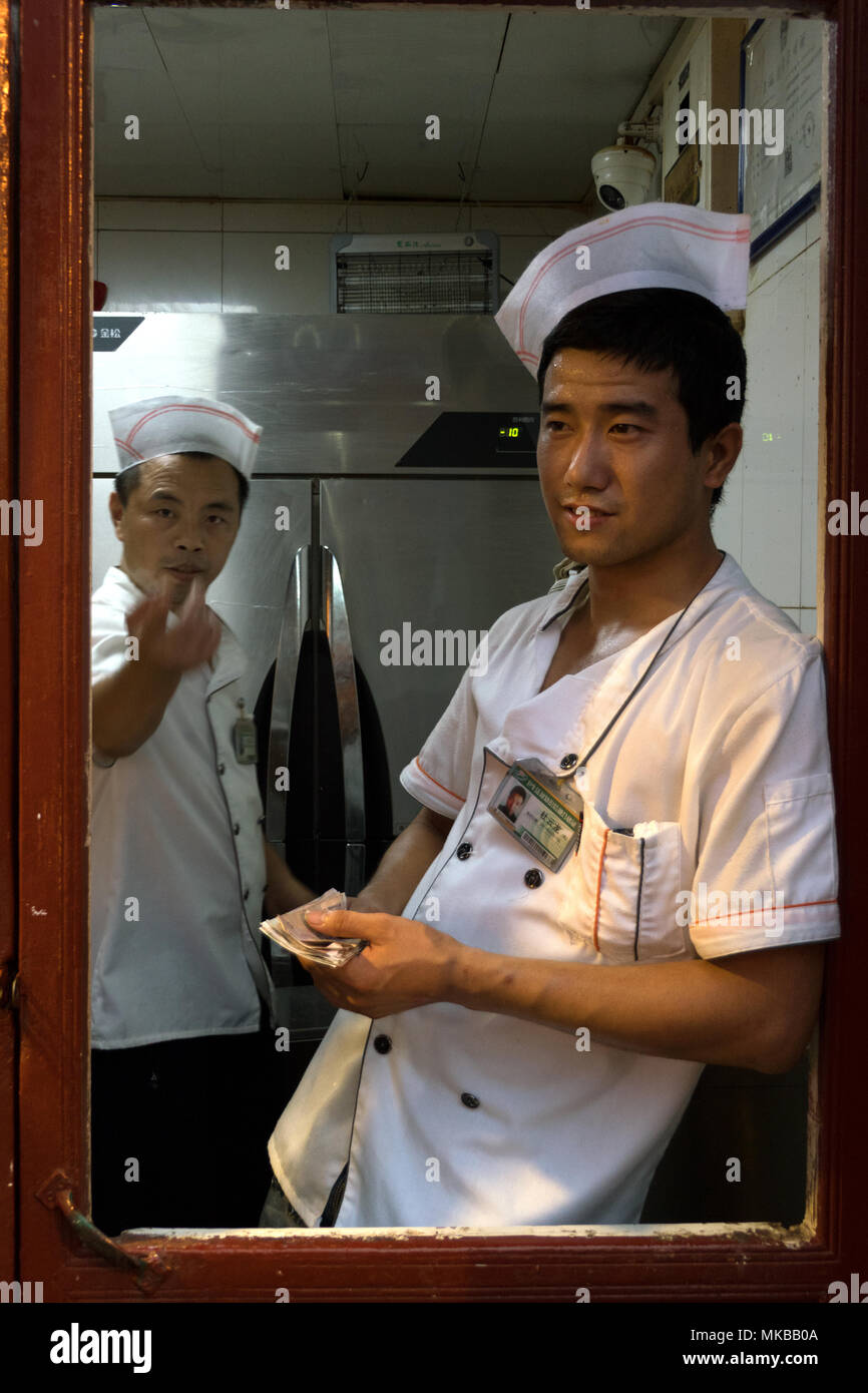 Chinese cook working in Asian restaurant kitchen in Beijing, China ...