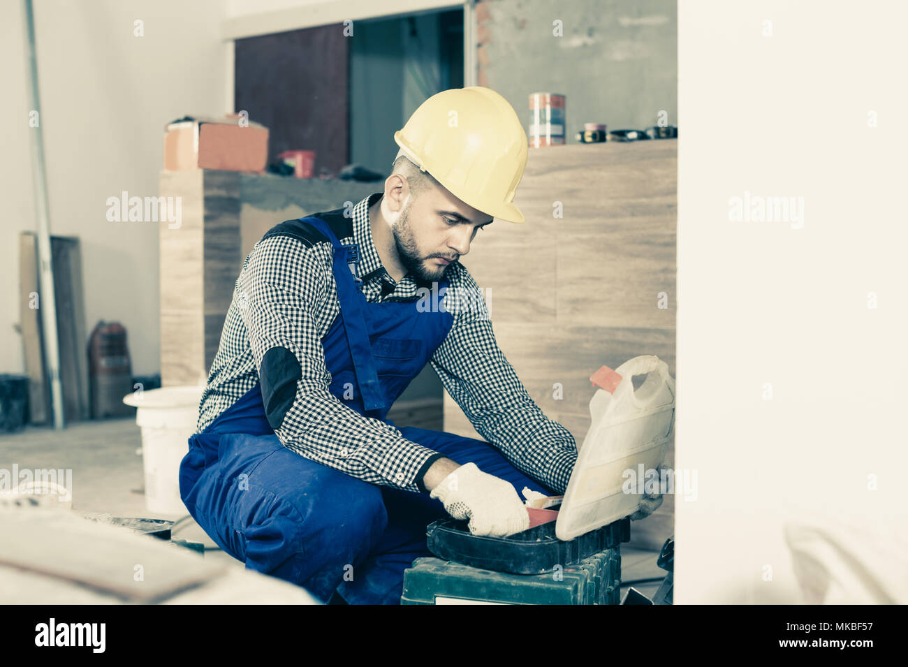 Diligent efficient serious builder is choosing tools in suitcase for ... Diligent efficient serious builder is choosing tools in suitcase for ...