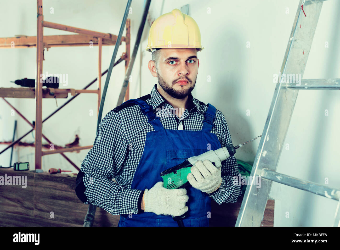Diligent male worker is ready to work with a dril at the object Stock ...
