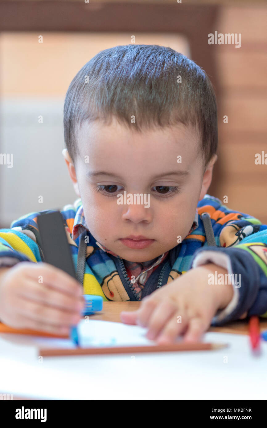 Cute little boy writing something in notebook Stock Photo - Alamy