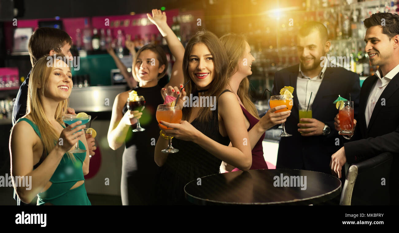 Cheerful employees dancing on corporate party with alcohol in hands ...