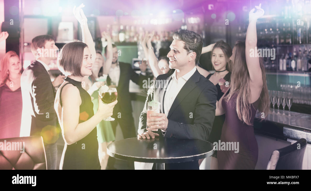 Happy smiling colleagues dancing on corporate party with cocktails in ...