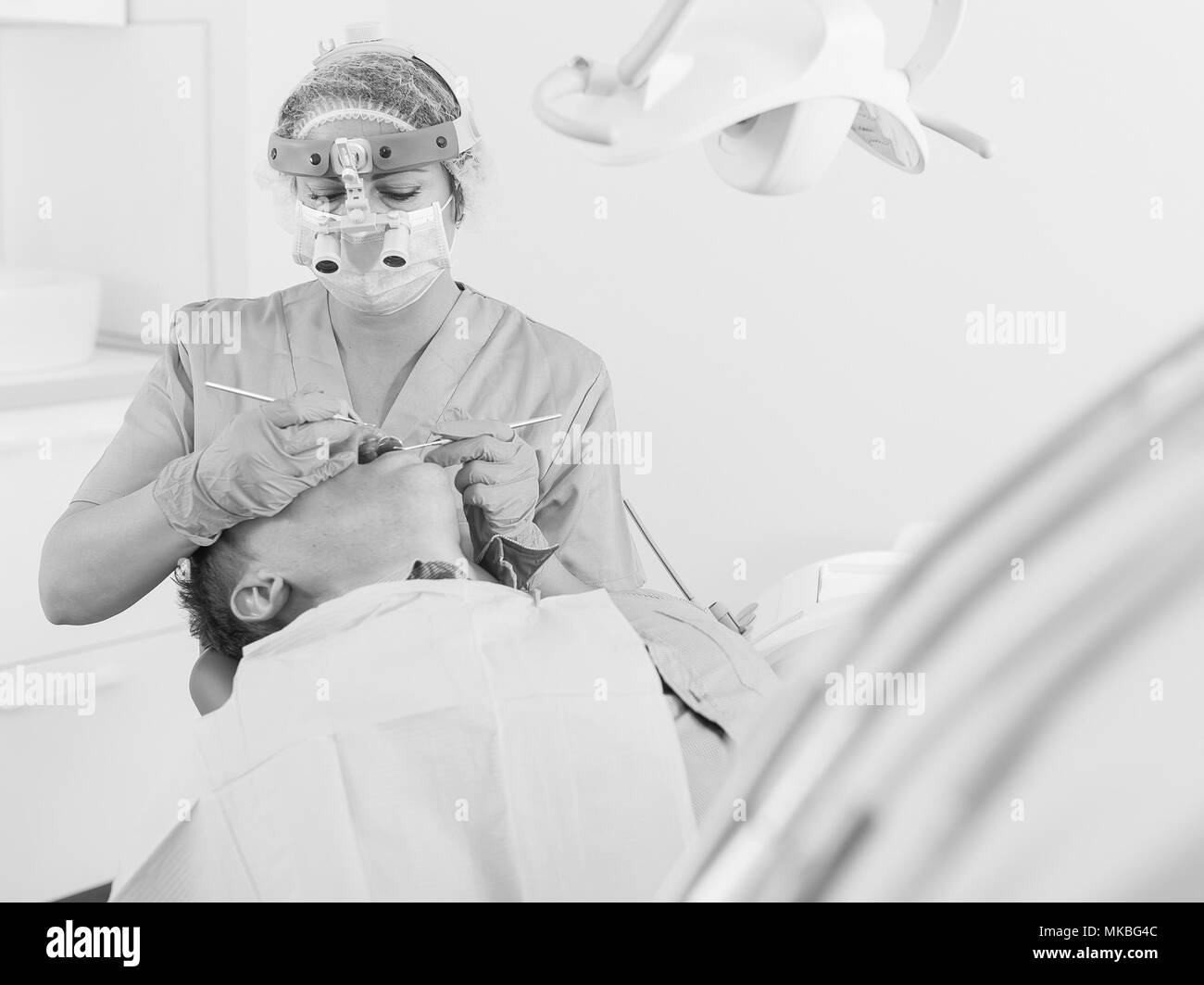 adult dentist checking teeth of patient male sitting in medical center ...